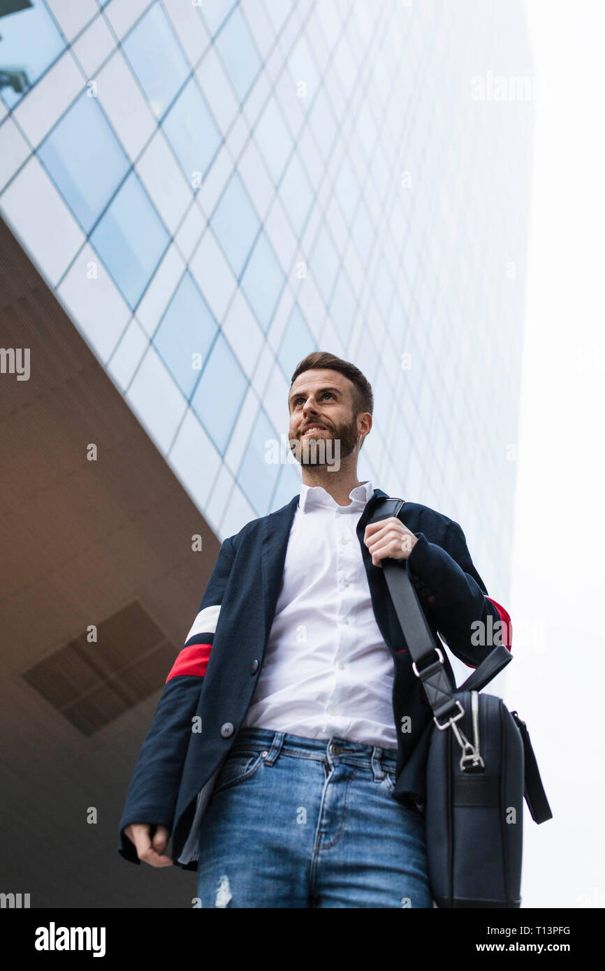 Stylish businessman in front of office building looking around Stock ...