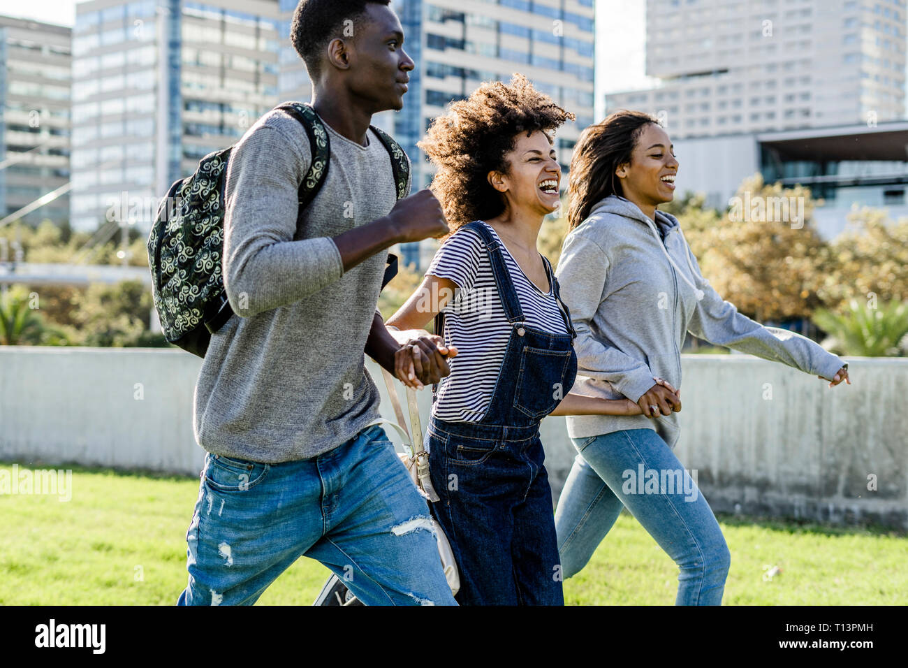 Three friends running lawn city hi-res stock photography and images - Alamy