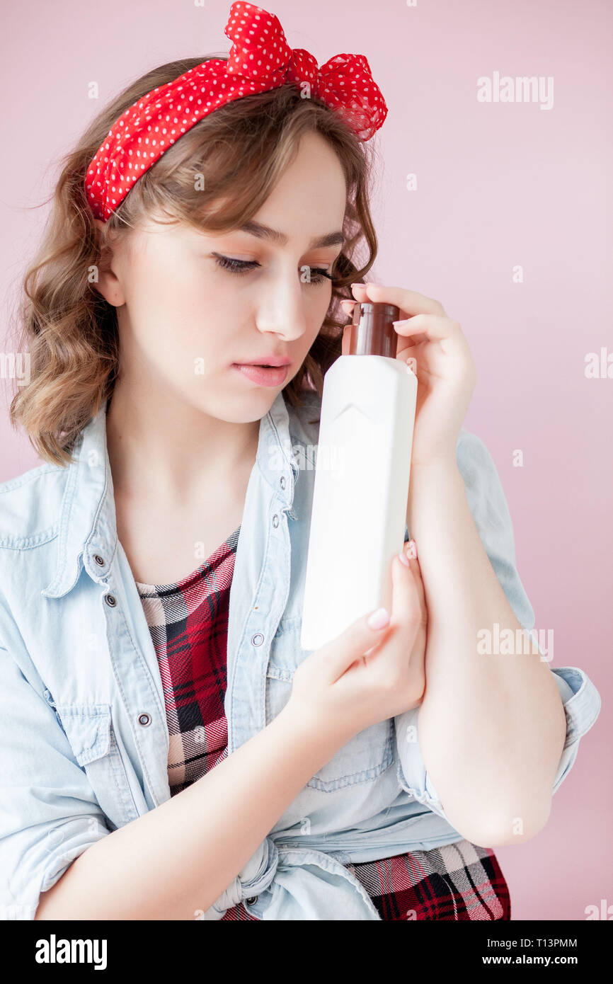 Beautiful young woman with pin-up make-up and hairstyle with cleaning ...