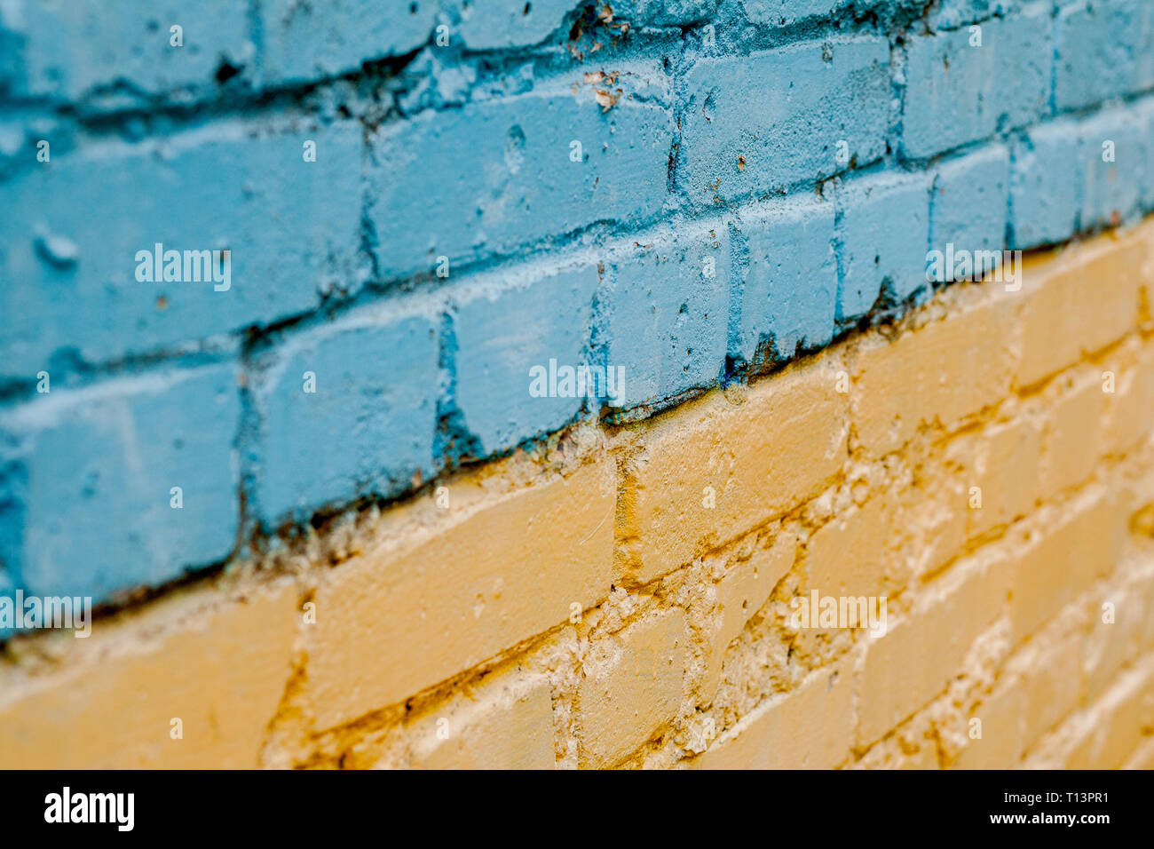 Ukraine flag painted on old brick wall, background of yellow-blue brick ...