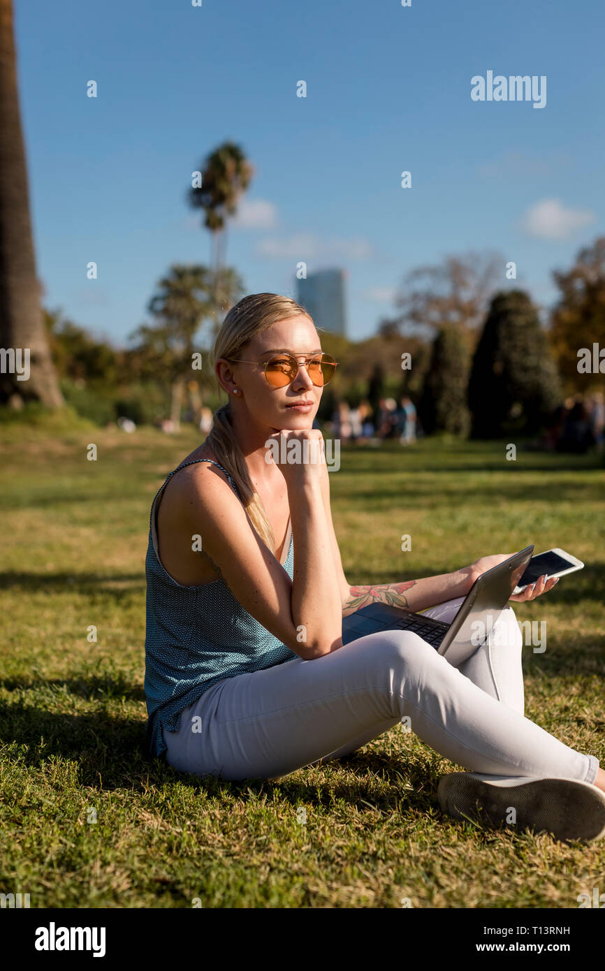 Young woman sitting park hi-res stock photography and images - Alamy