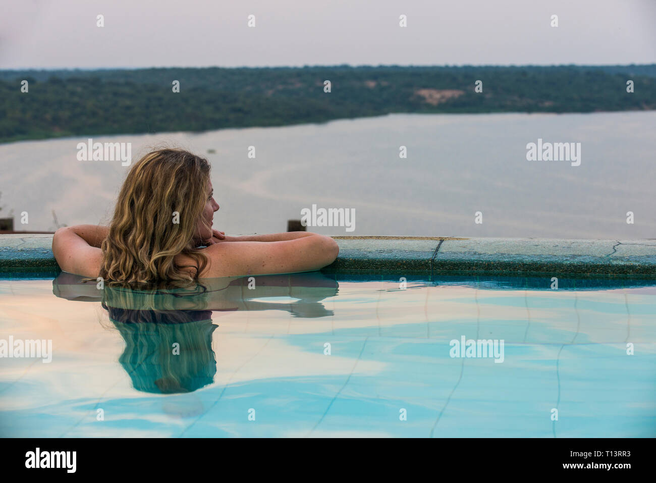 Africa, Uganda, Queen Elizabeth National Park, Woman relaxing in a pool ...