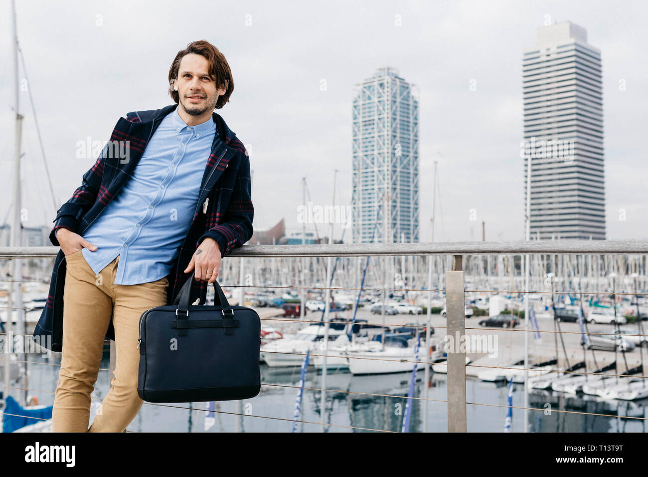 Spain, Barcelona, relaxed man after work with port and city background ...