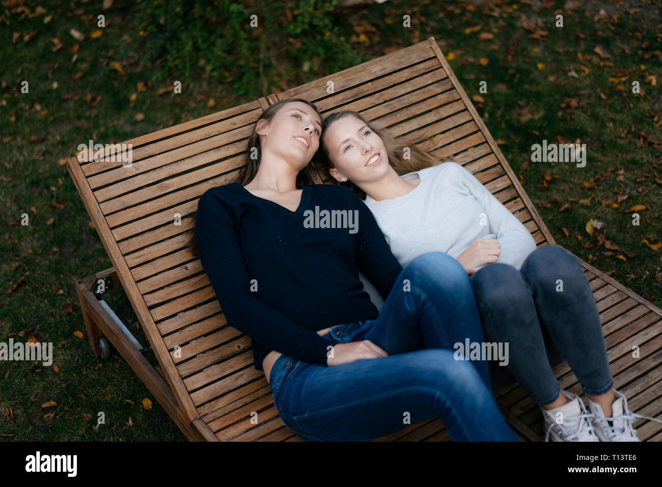 Two affectionate thoughtful teenage girls resting on sun lounger Stock ...