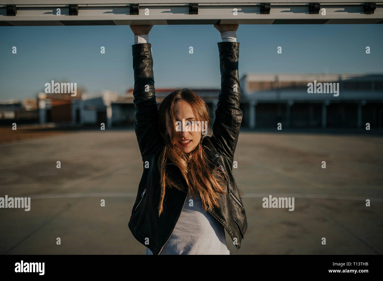 Portrait of young woman hanging at goal on sports field Stock Photo - Alamy