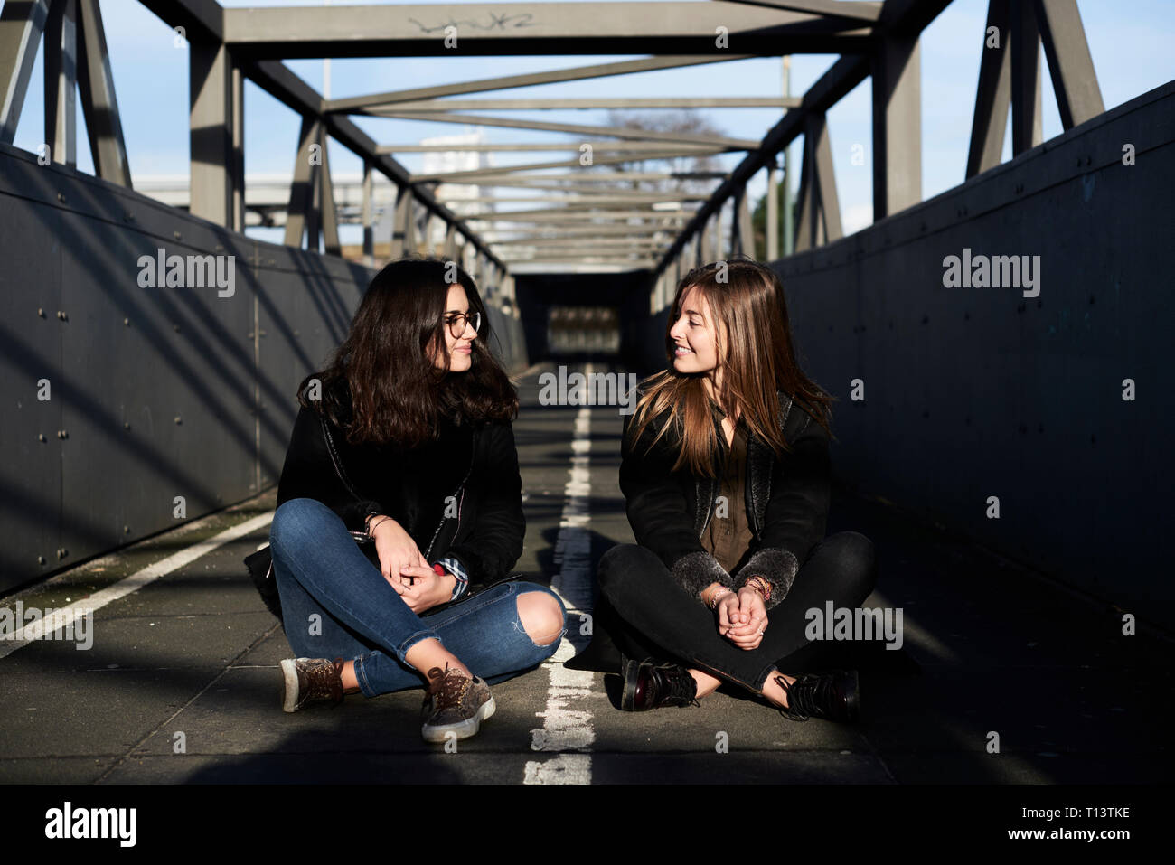 Two friends sitting on bridge hi-res stock photography and images - Alamy