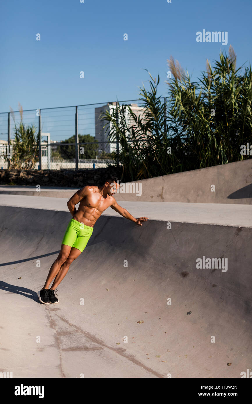 Barechested muscular man exercising in a skatepark Stock Photo - Alamy