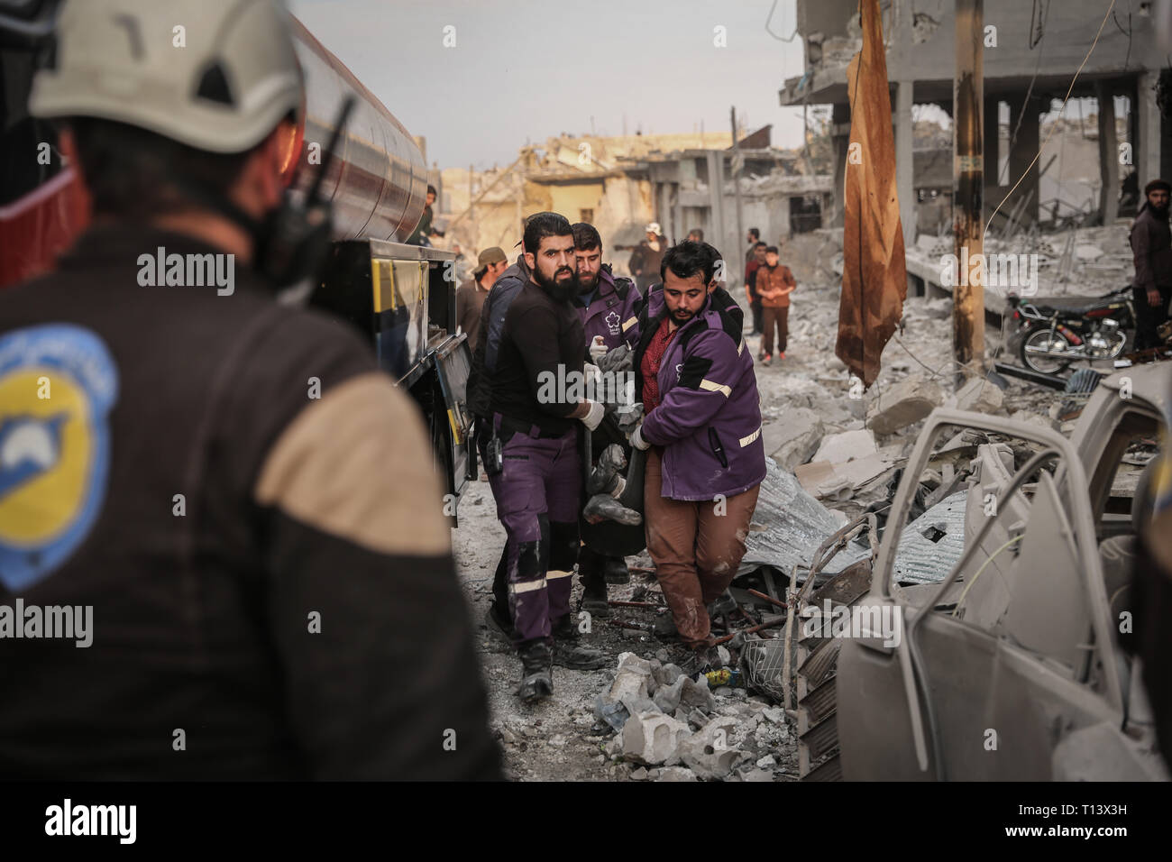 Idlib, Syria. 22nd Mar, 2019. Syrians look for salvageable items in the ...