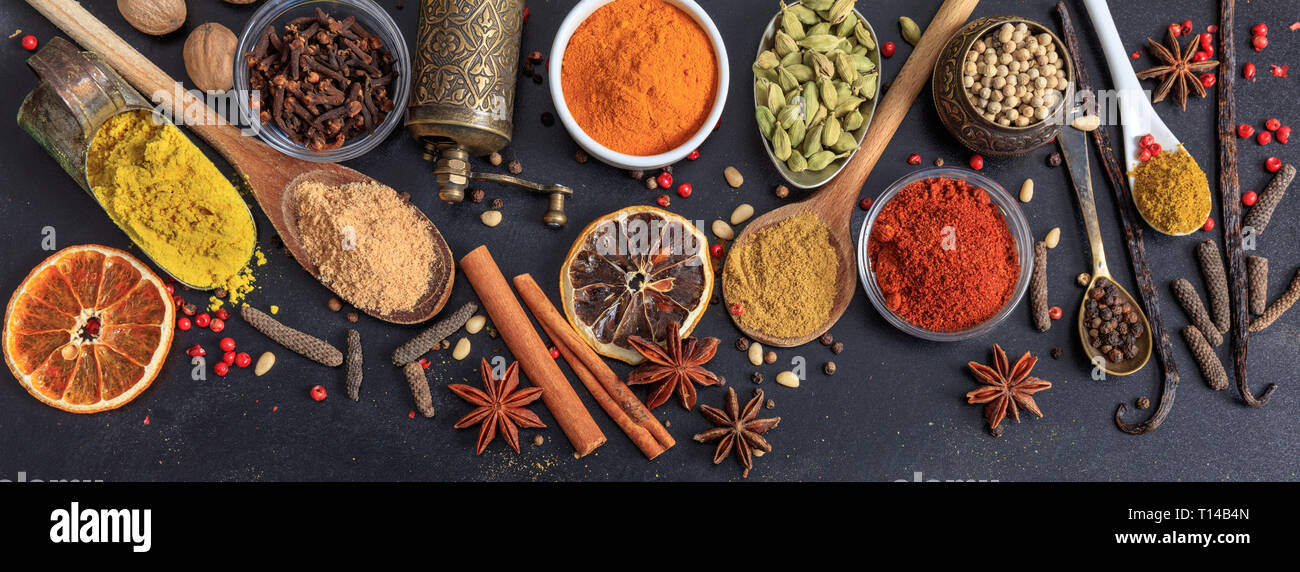 Spices and herbs. Colorful spices flat lay on wooden table, banner ...