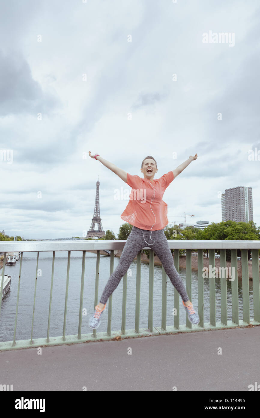smiling fit sports woman in fitness clothes in Paris, France jumping ...