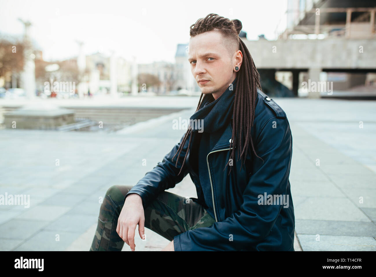 rocker rock star young caucasian man with dreadlocks walking on the ...