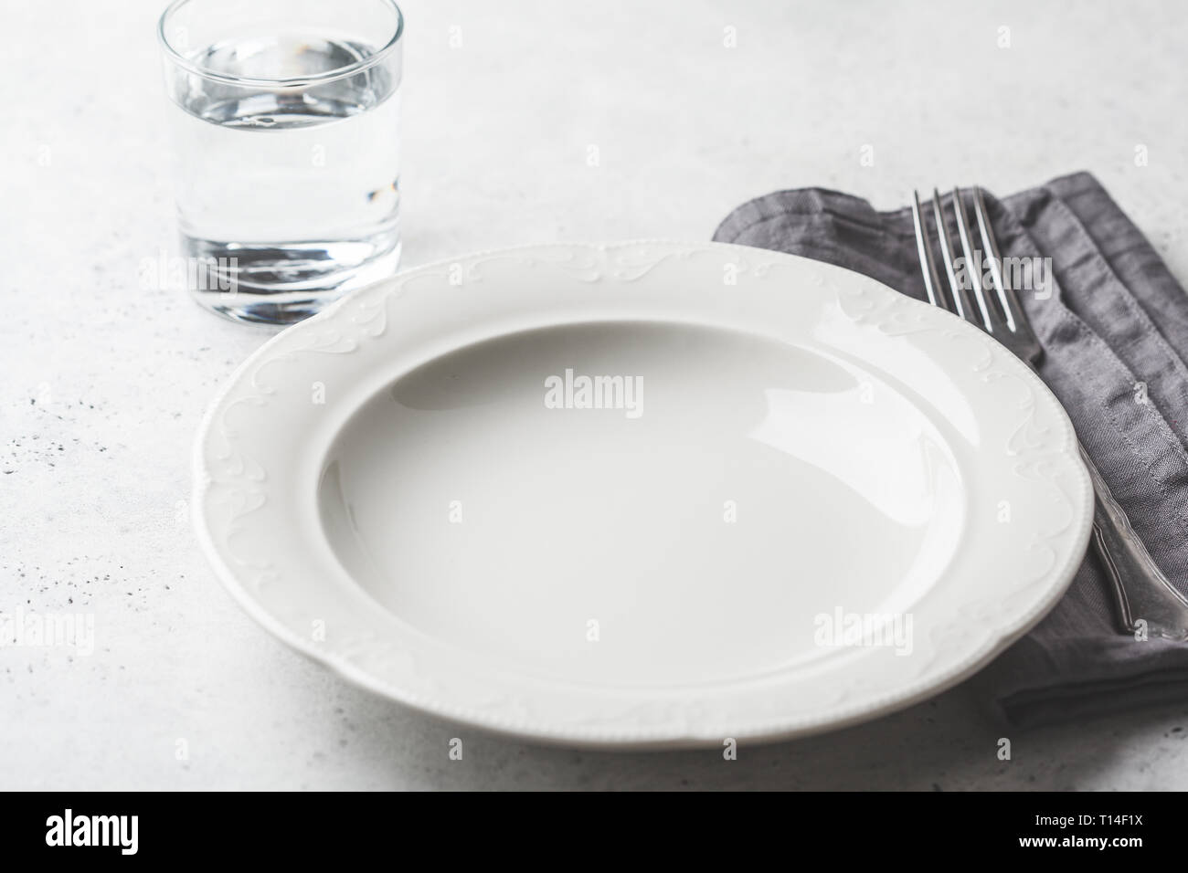 Empty plate and glass of water, white background, copy space. Medical ...
