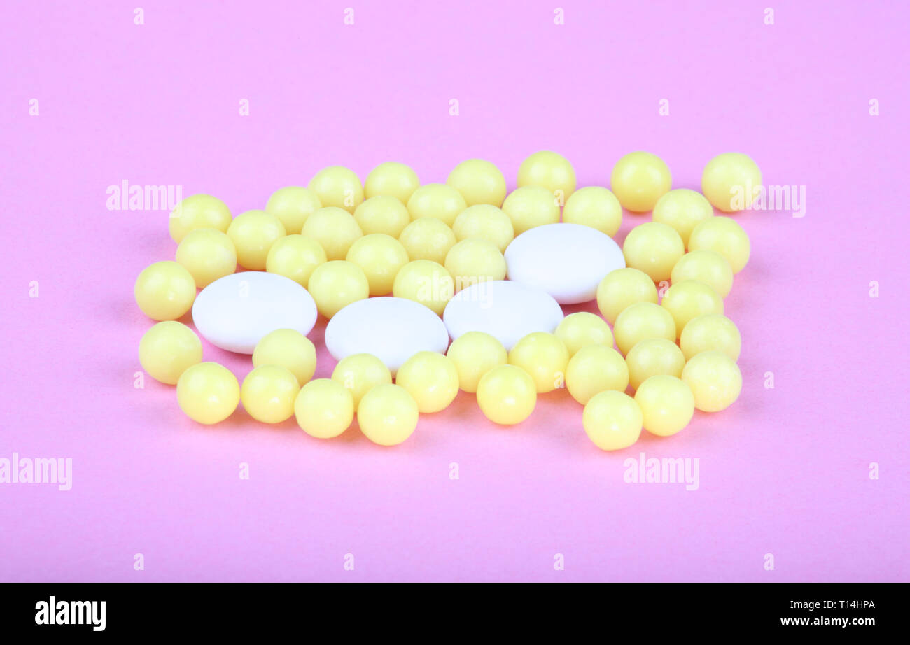 yellow vitamins on pink background Stock Photo - Alamy