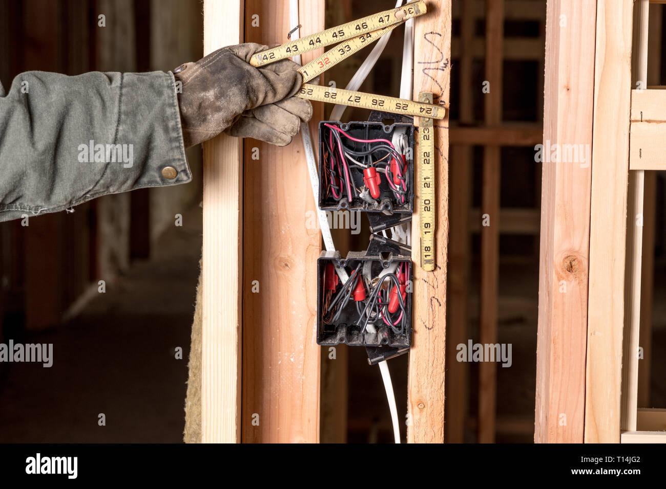 Space between studs is measured with a ruler by a construction worker ...