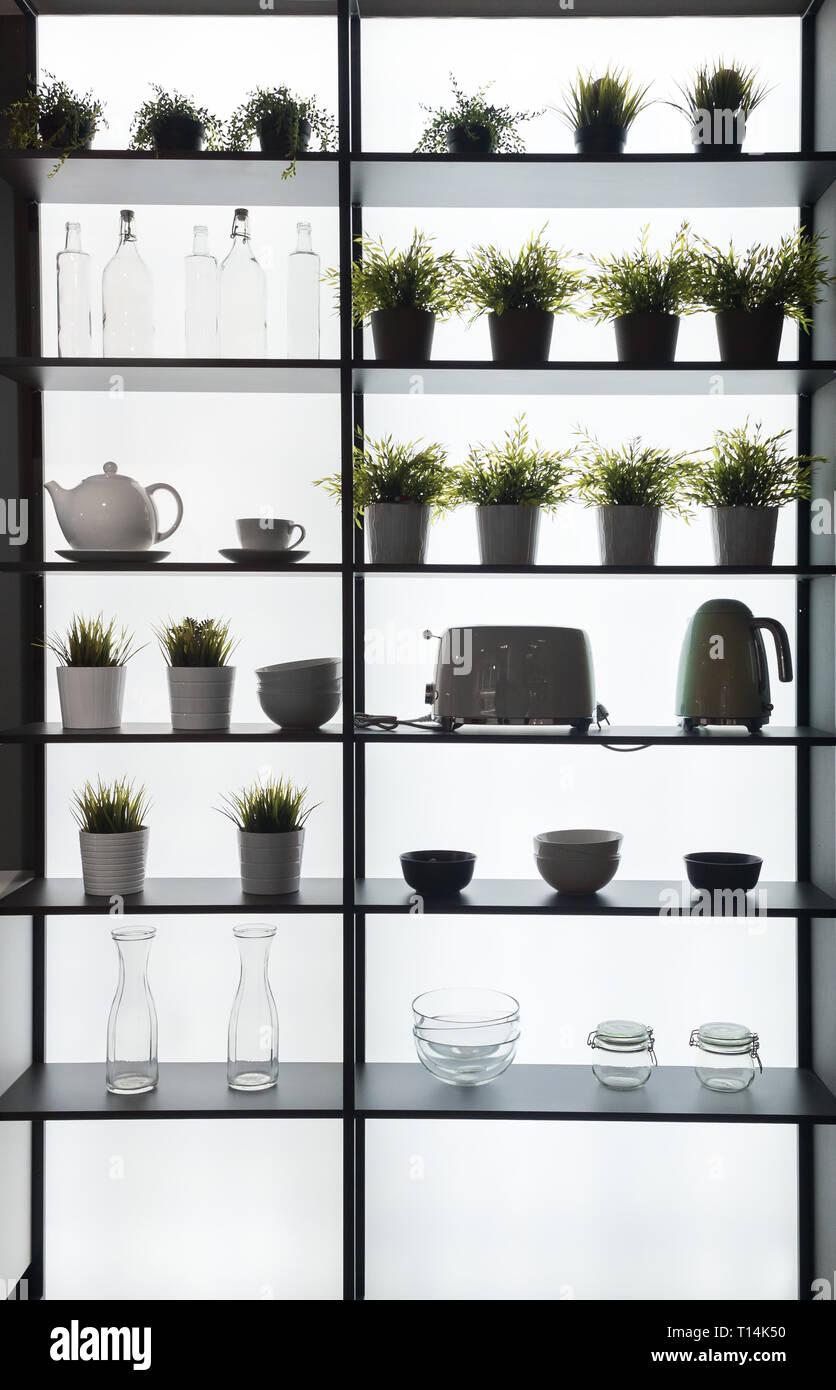 Backlit shelf with various kitchenware silhouettes. Glass jars teapot ...