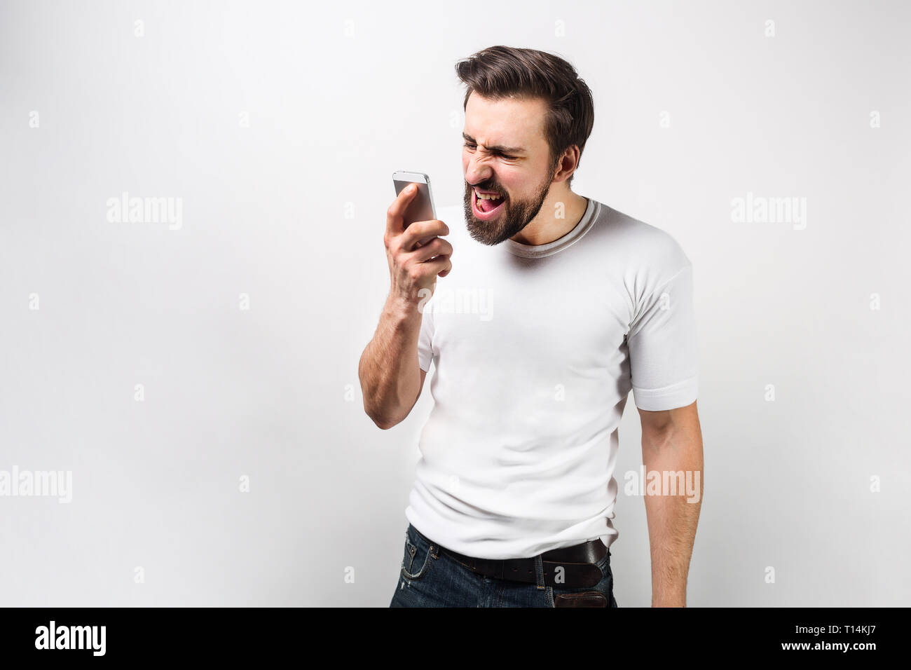 Strong and big guy is talking on the phone aloud. He is screaming words ...