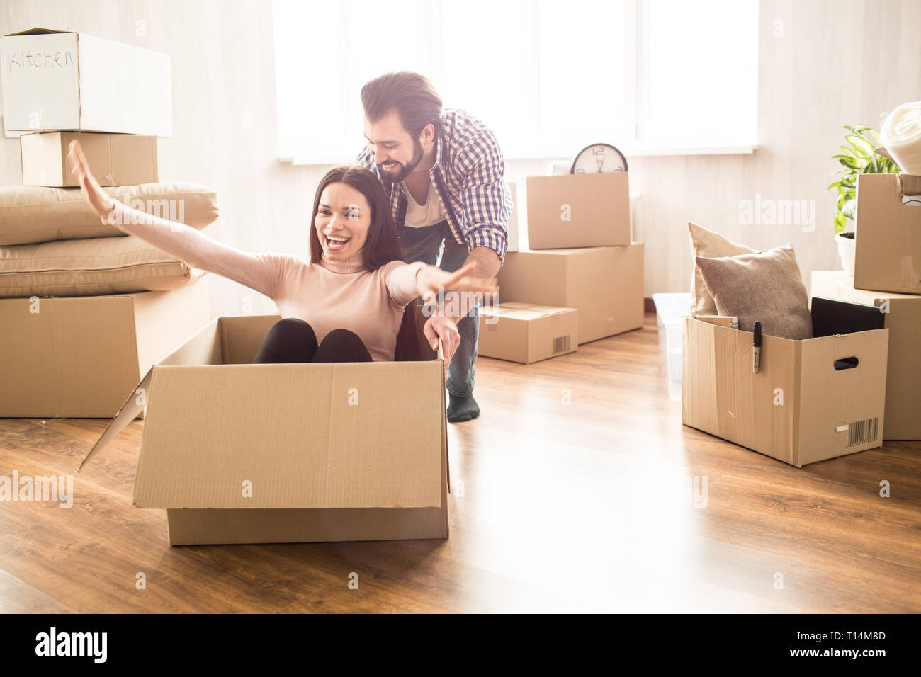 Attractive woman is sitting on the box. Her man is pushing her so she ...