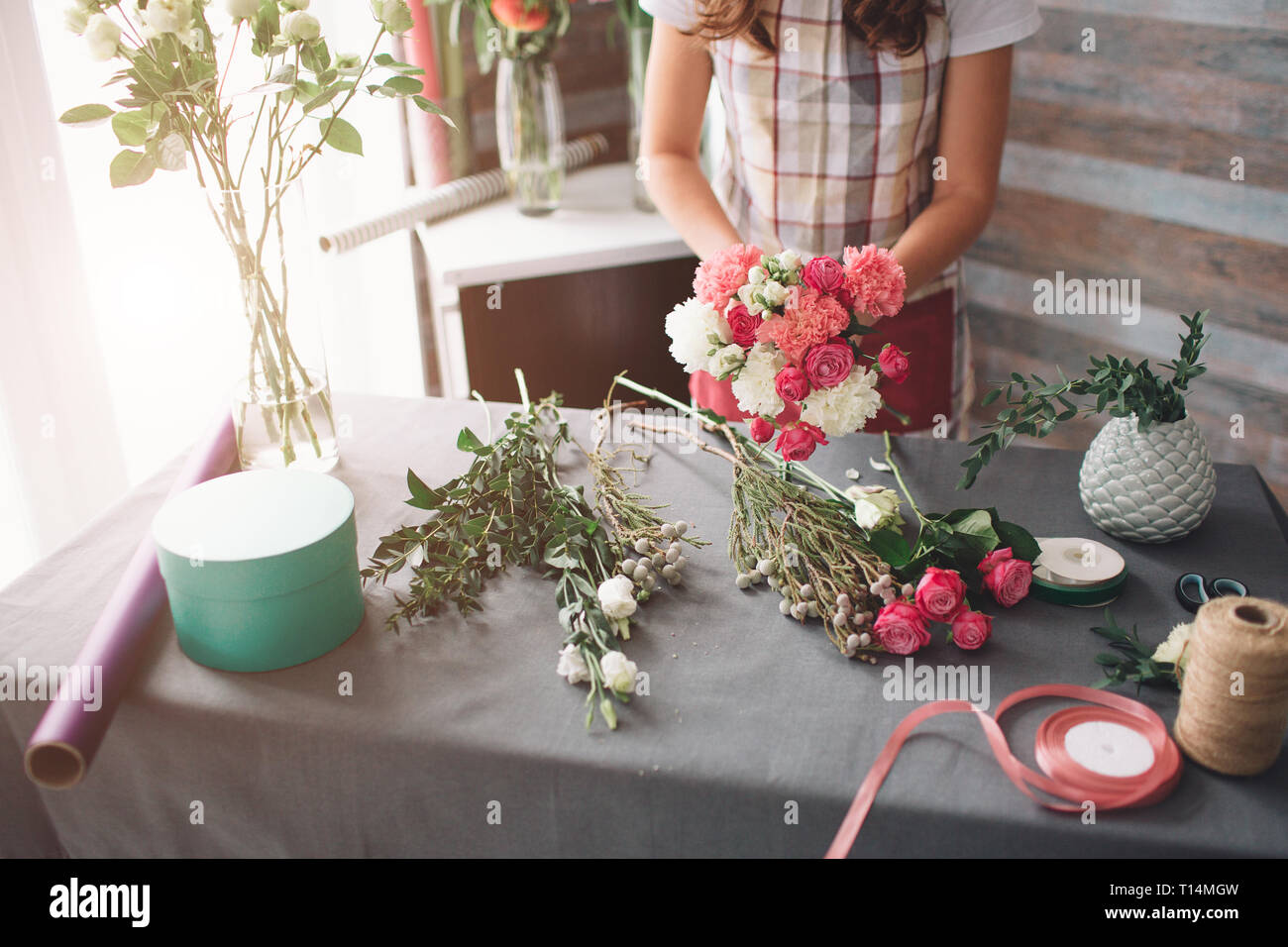 Female florist at work: pretty young dark-haired woman making fashion ...
