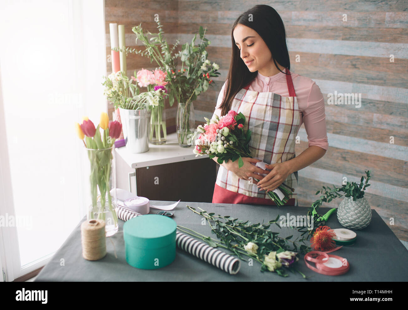 Female florist at work: pretty young dark-haired woman making fashion ...