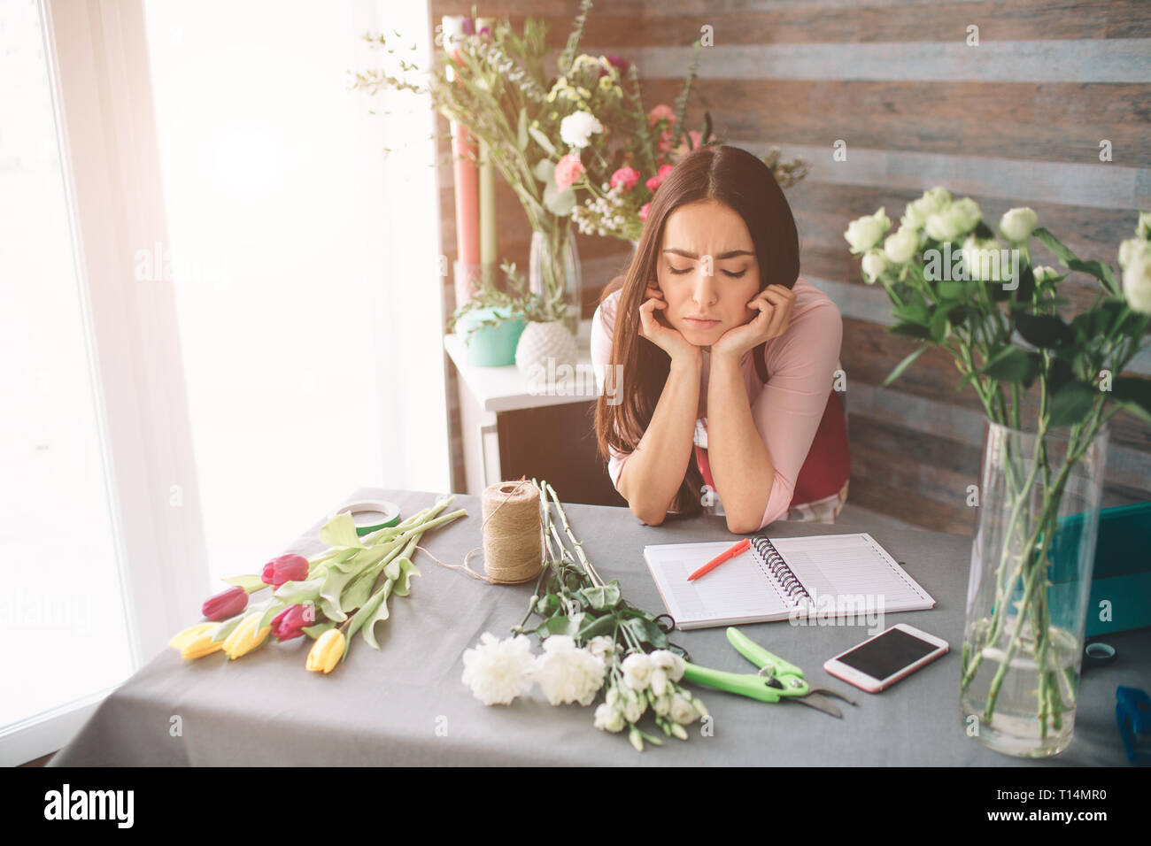 Female florist at work: pretty young dark-haired woman making fashion ...