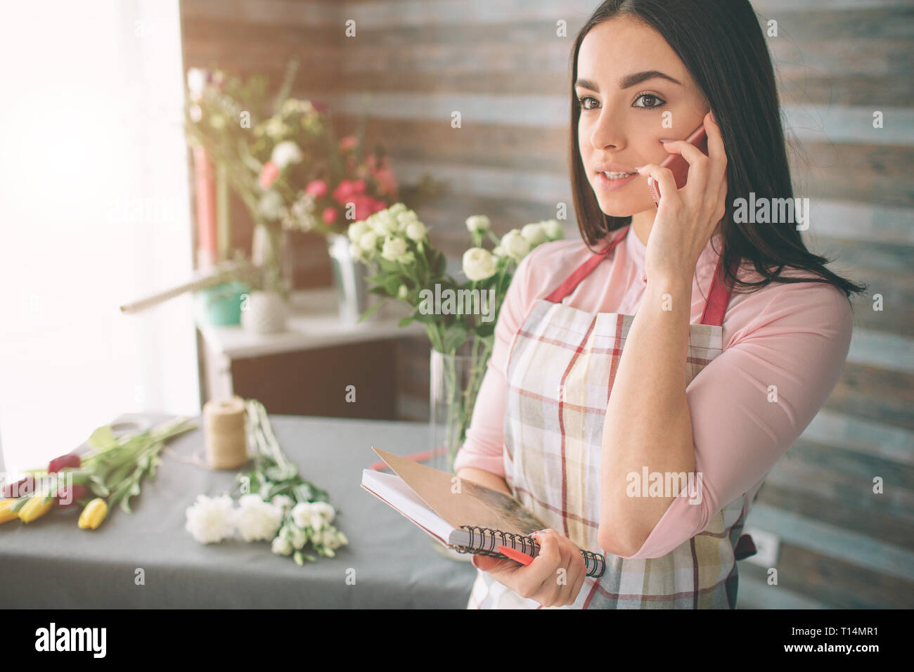 Female florist at work: pretty young dark-haired woman making fashion ...