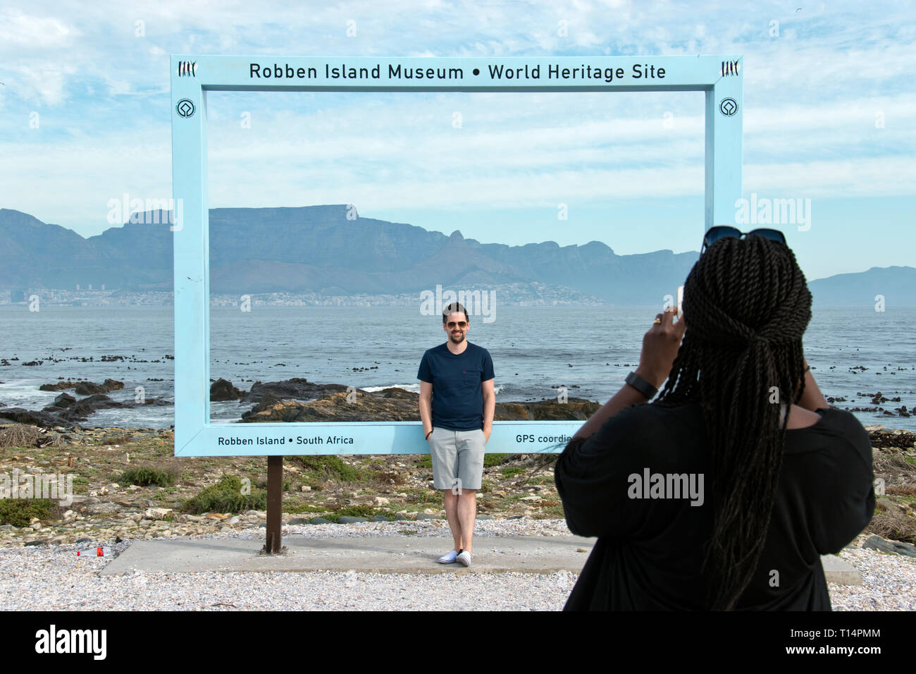 Tourist makes a photo with Table Mountain in background, at Robben ...