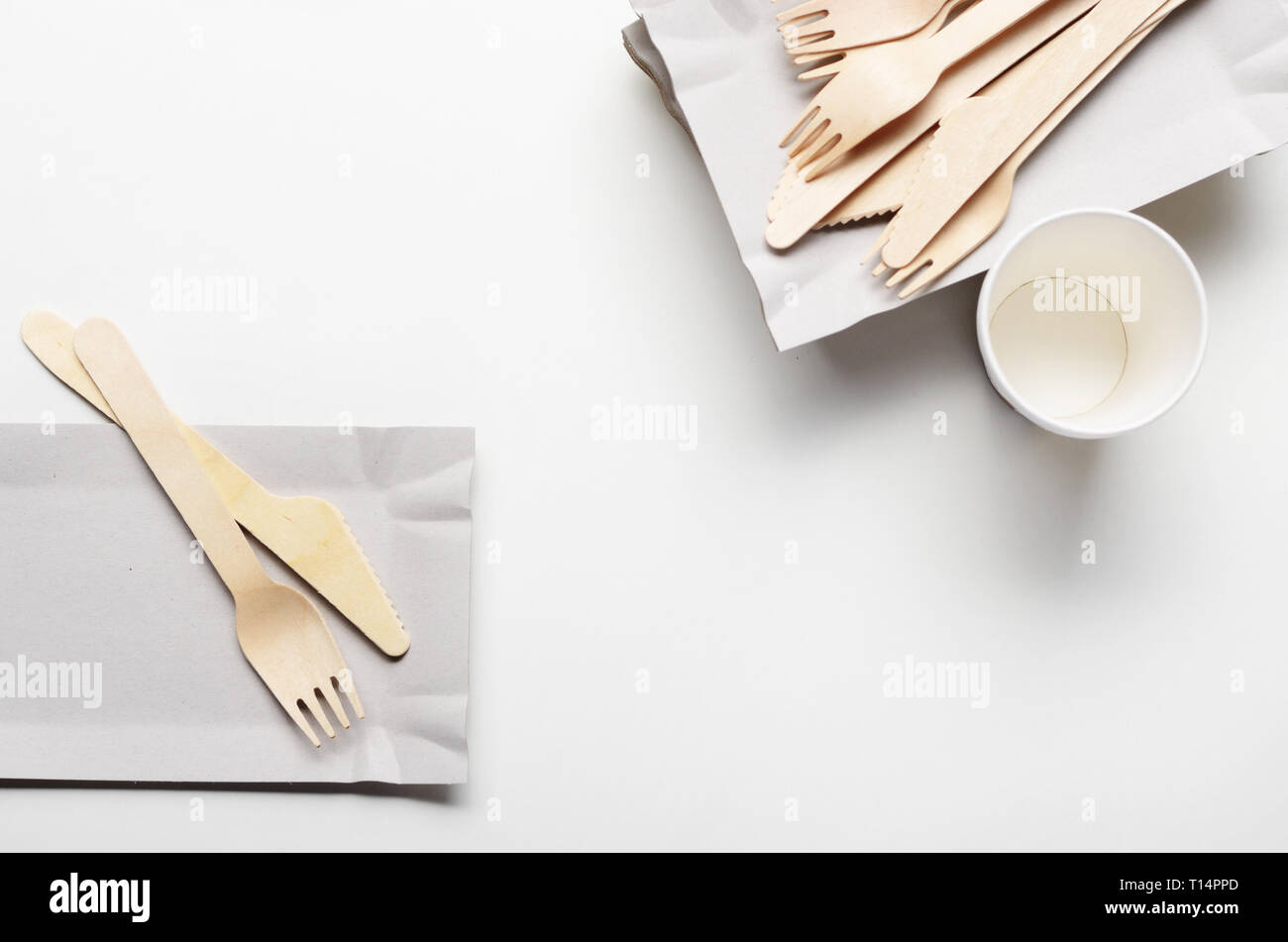 Wooden single use kitchenware and paper cups and plates on white ...