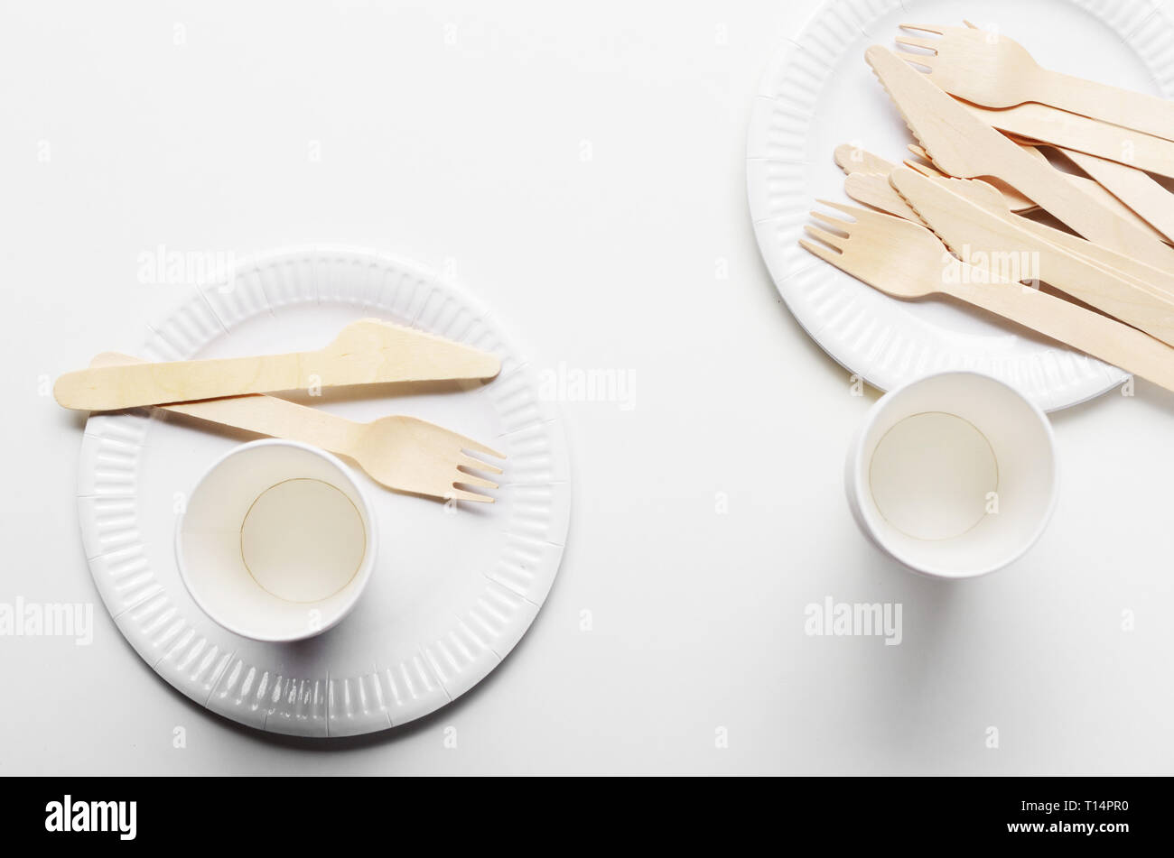 Wooden single use kitchenware and paper cups and plates on white ...