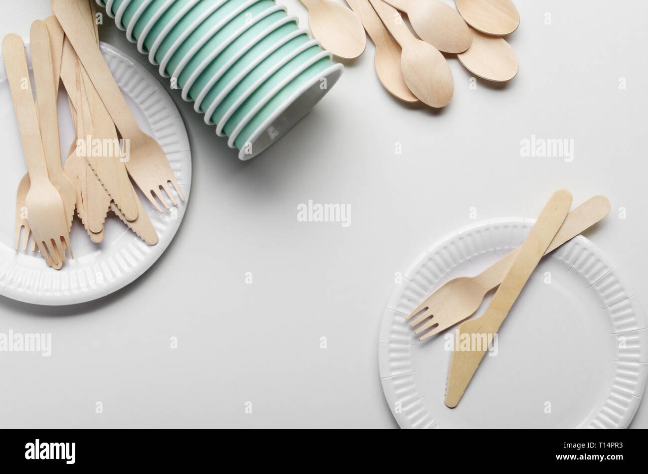 Wooden single use kitchenware and paper cups and plates on white. Top ...