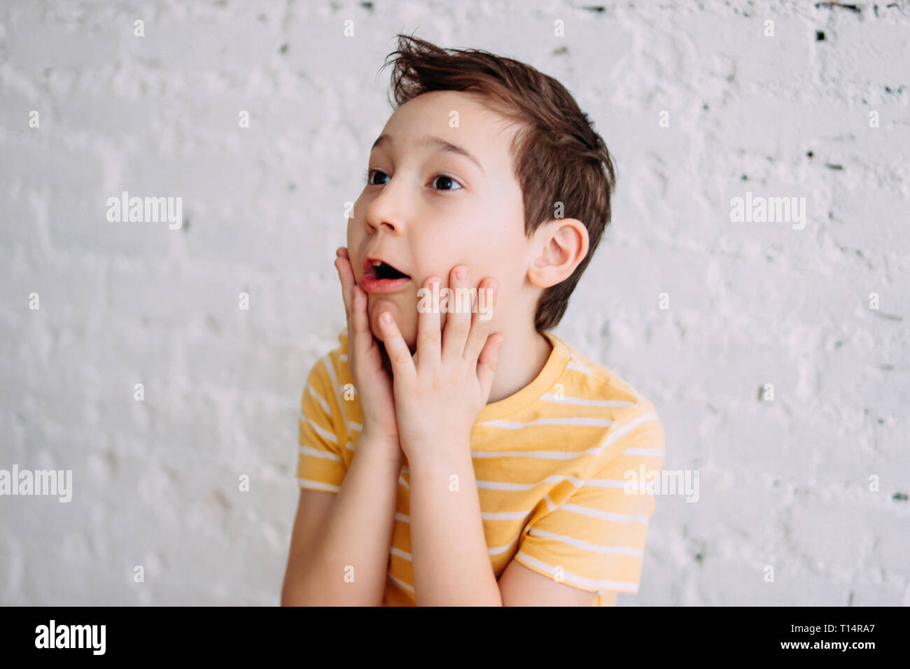 Cute tween surprised boy with funny face in yellow t-shirt isolated on ...