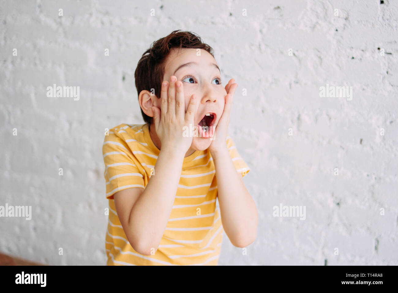 Cute tween surprised boy with funny face in yellow t-shirt isolated on ...