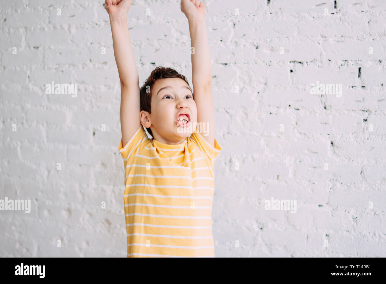 Cute tween happy win boy with funny face in yellow t-shirt isolated on ...