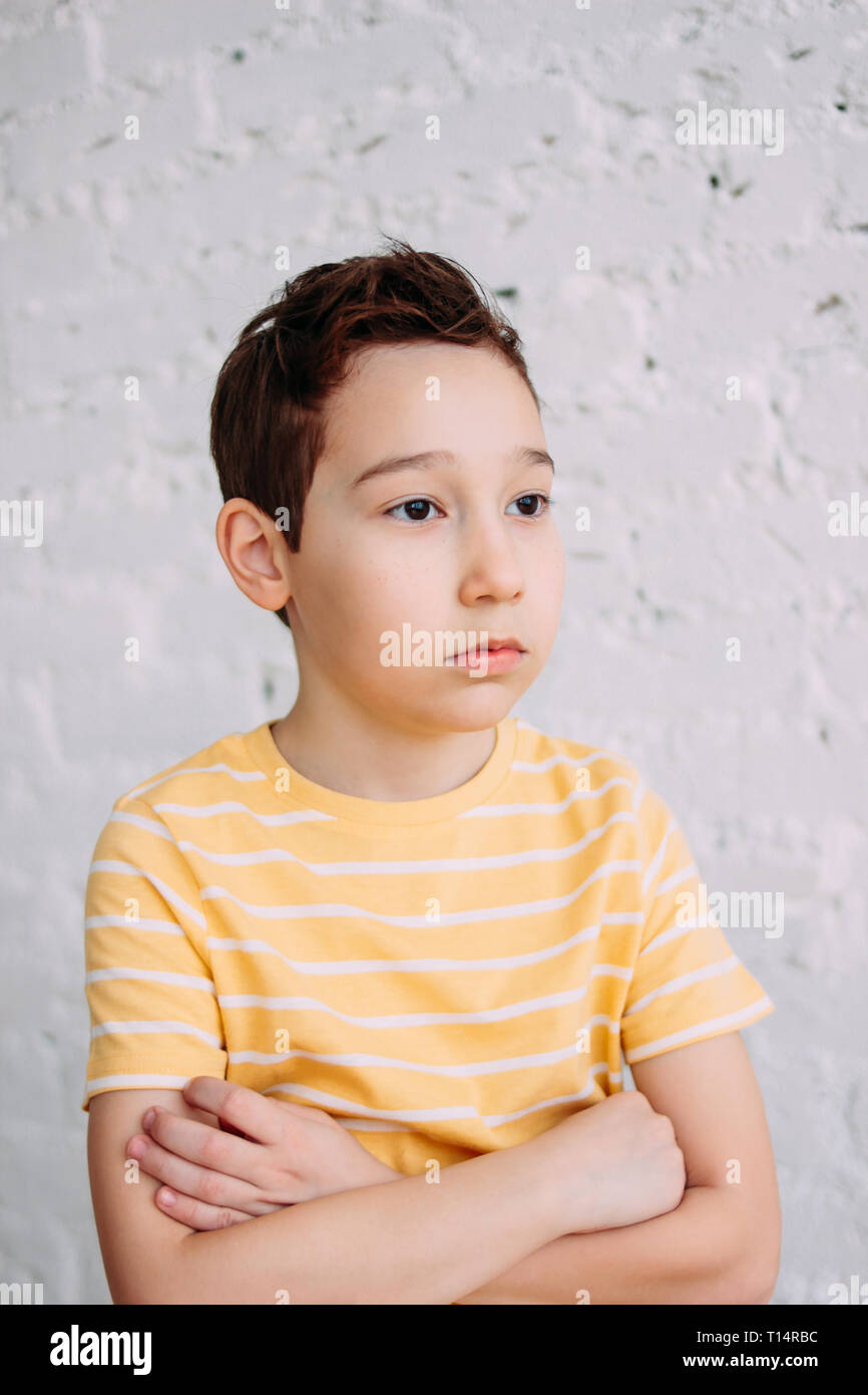 Cute tween indifferent sad boy in yellow t-shirt making kiss by hands ...