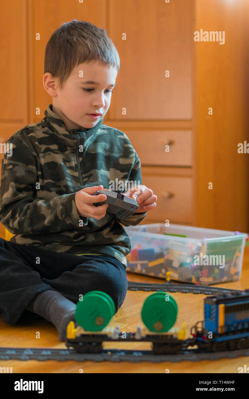 Five year old boy playing on the floor by rail. Little boy playing with ...