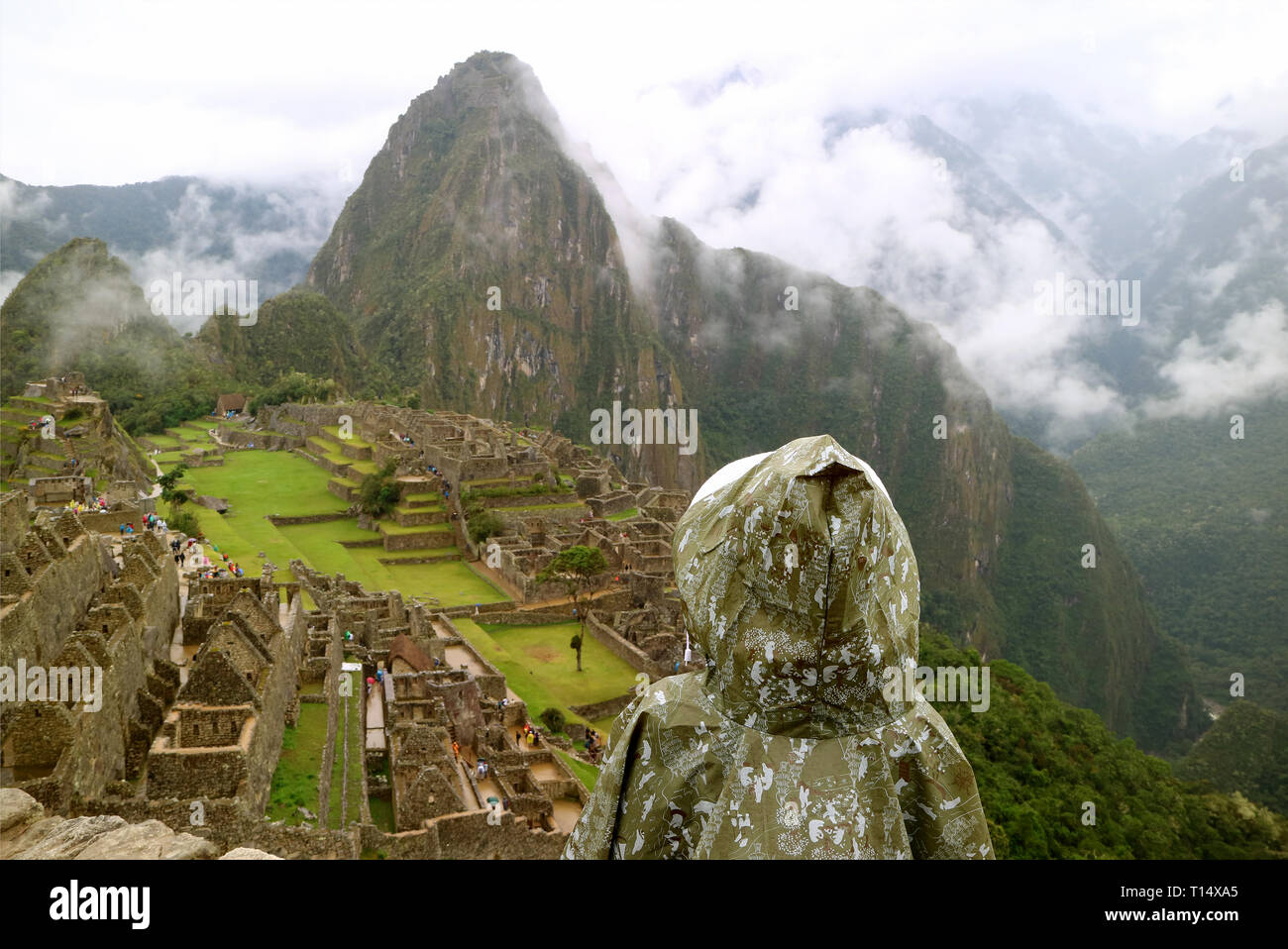 Female visitor wearing raincoat full of raindrops Looking at the Machu ...