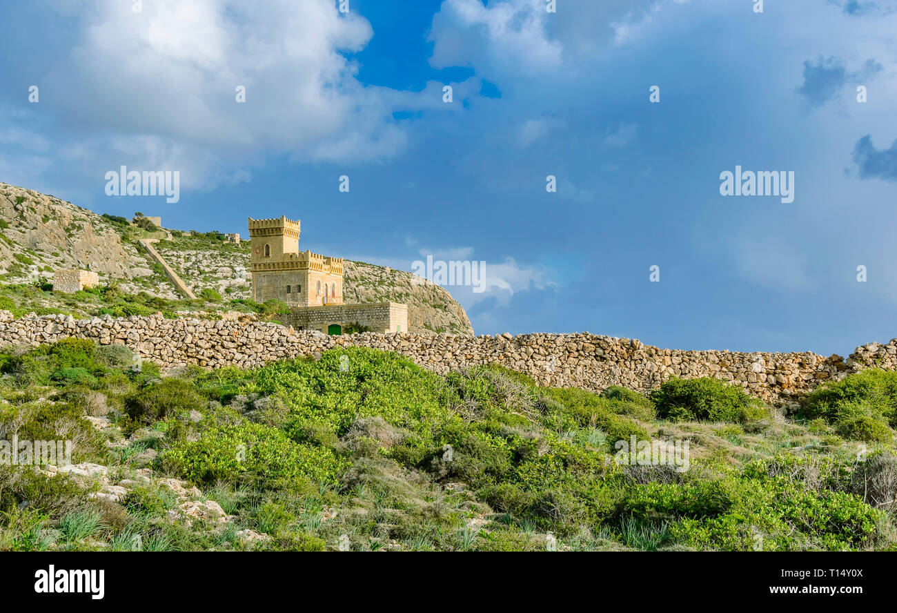 Ghar Lapsi tower on a hilly landscape in Malta. Medieval watchtower ...