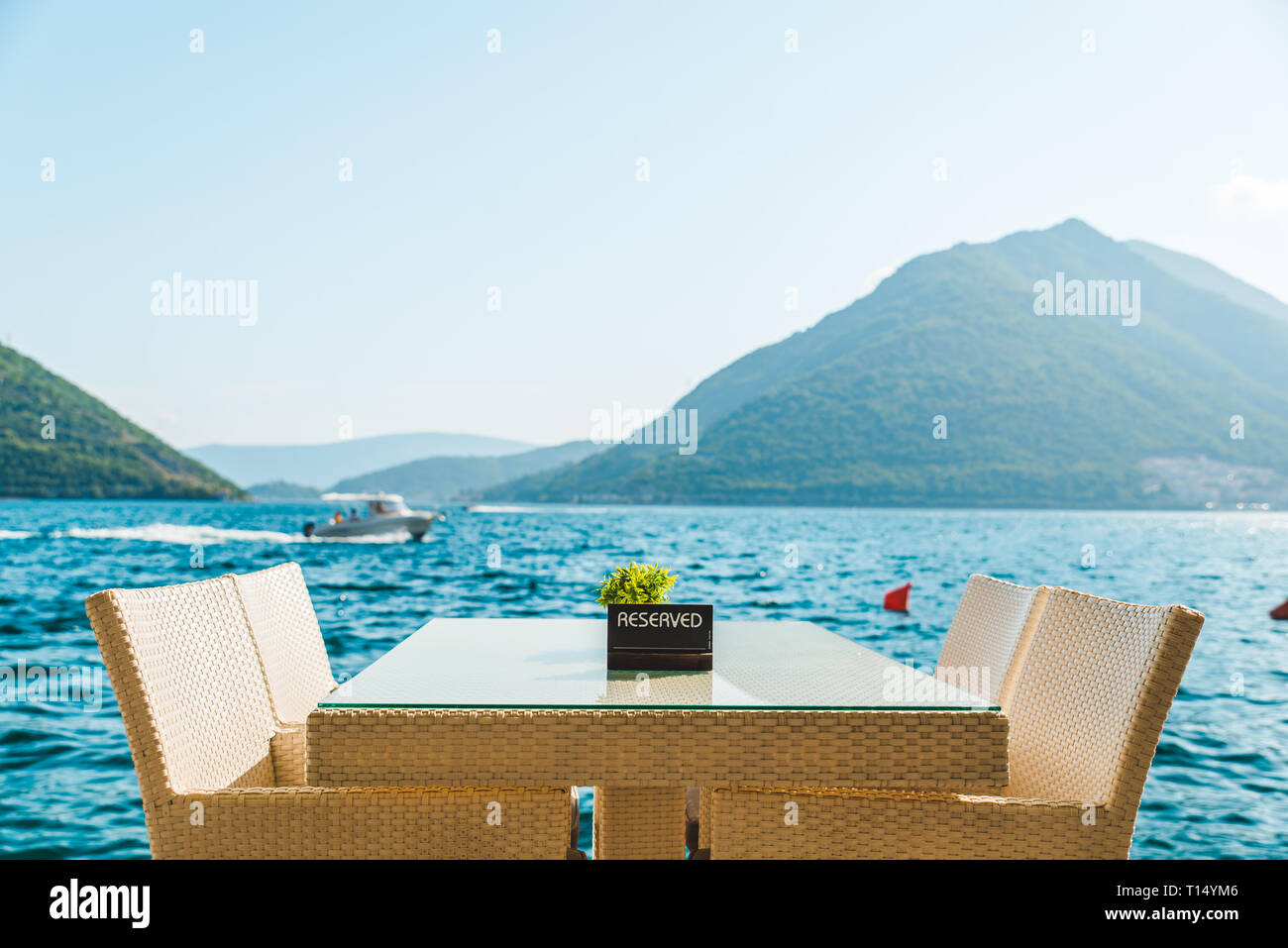 cafe table on beach with beautiful view of sea and mountains. reserved ...