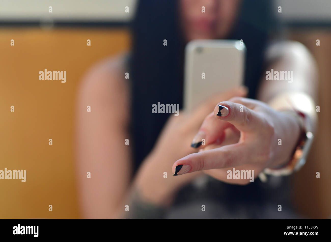 The brunette girl takes pictures of her two fingers (piece symbol) on a ...