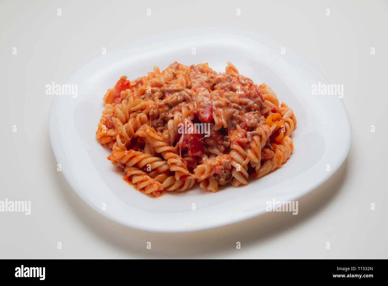 Cooked pasta in a white plate on white background Stock Photo - Alamy