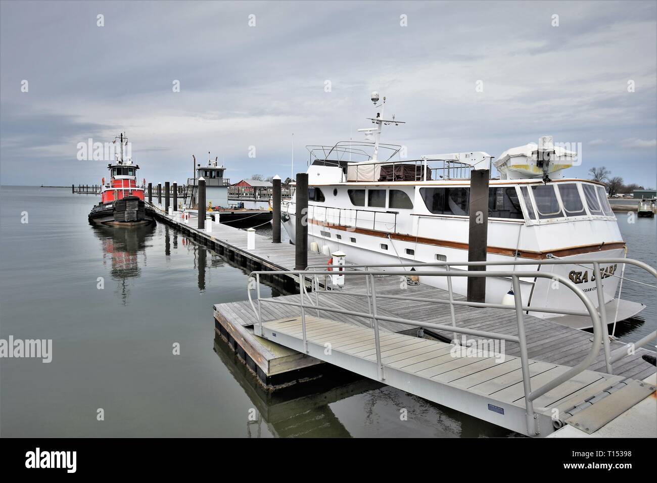 Tug boat and private pleasure motor yacht at dock in Cape Charles ...