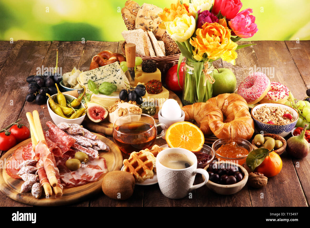 breakfast on table with bread buns, croissants, coffe and donuts Stock ...