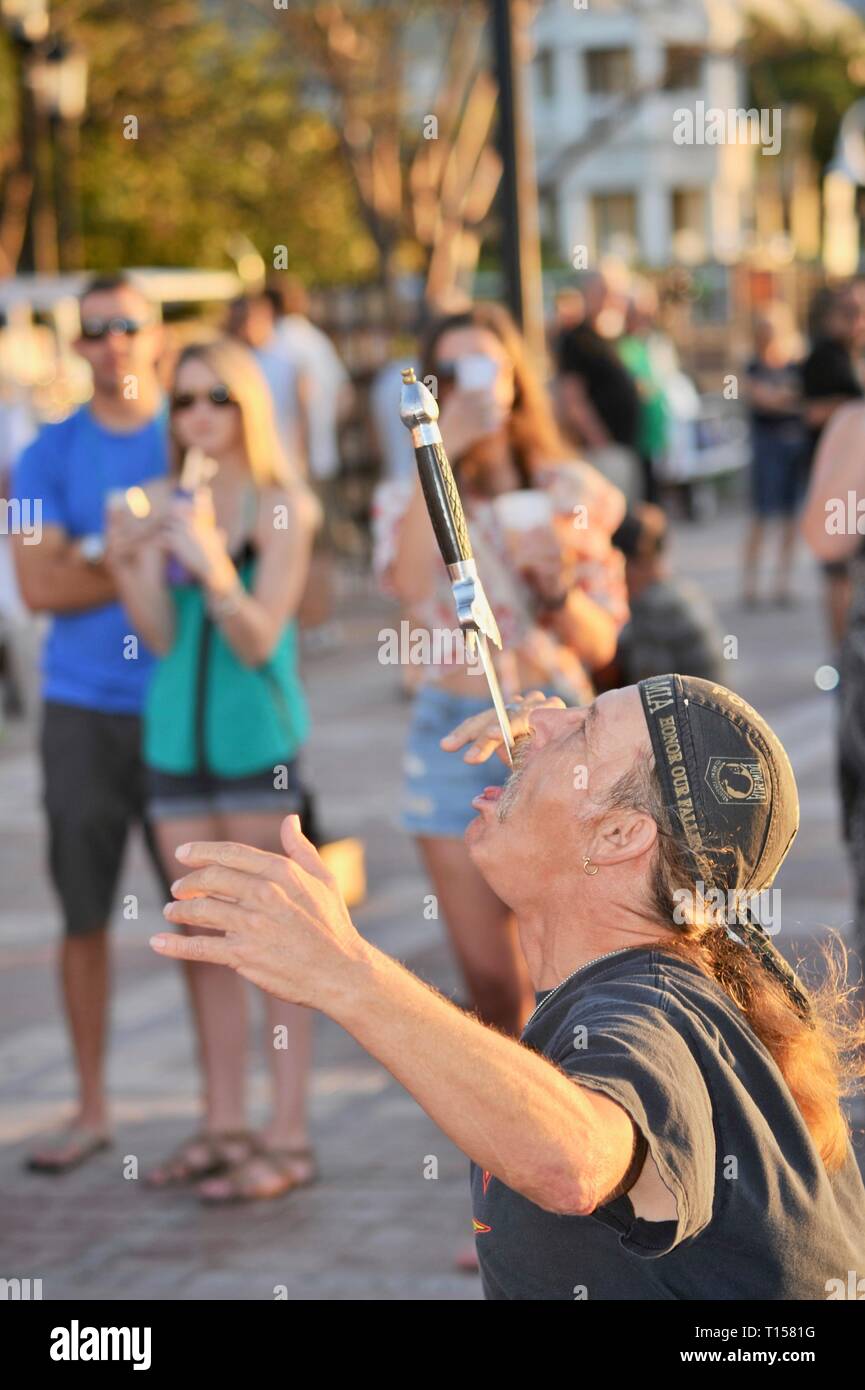 Swallowing sword street performer and entertainer, working for tips, at ...