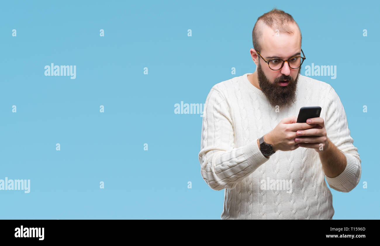 Young caucasian hipster man texting sending message using smartphone ...