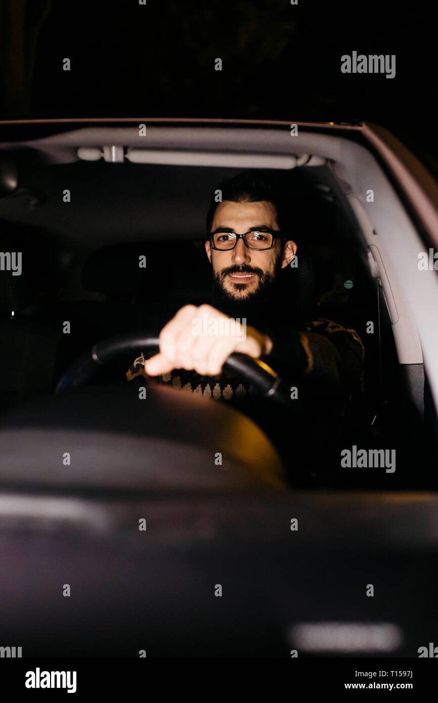 Portrait of confident man driving car at night Stock Photo - Alamy