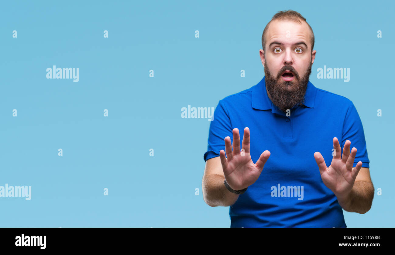 Young caucasian hipster man wearing blue shirt over isolated background ...
