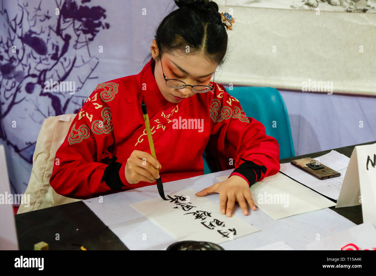 Japanese girl, with typical kimono, writes names in Japanese symbols ...