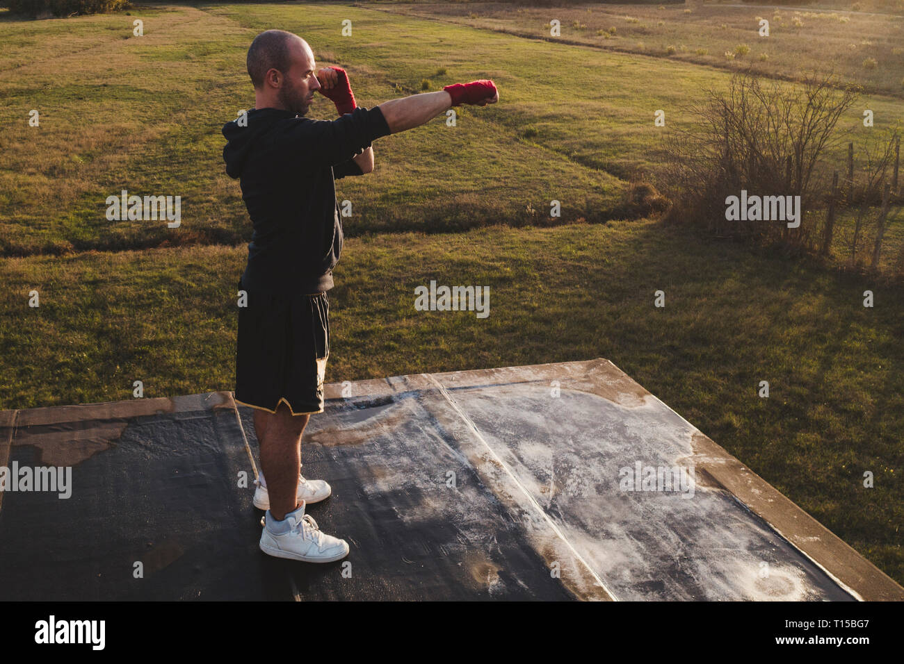 Boxer standing on platform in fighting pose outdoors Stock Photo - Alamy