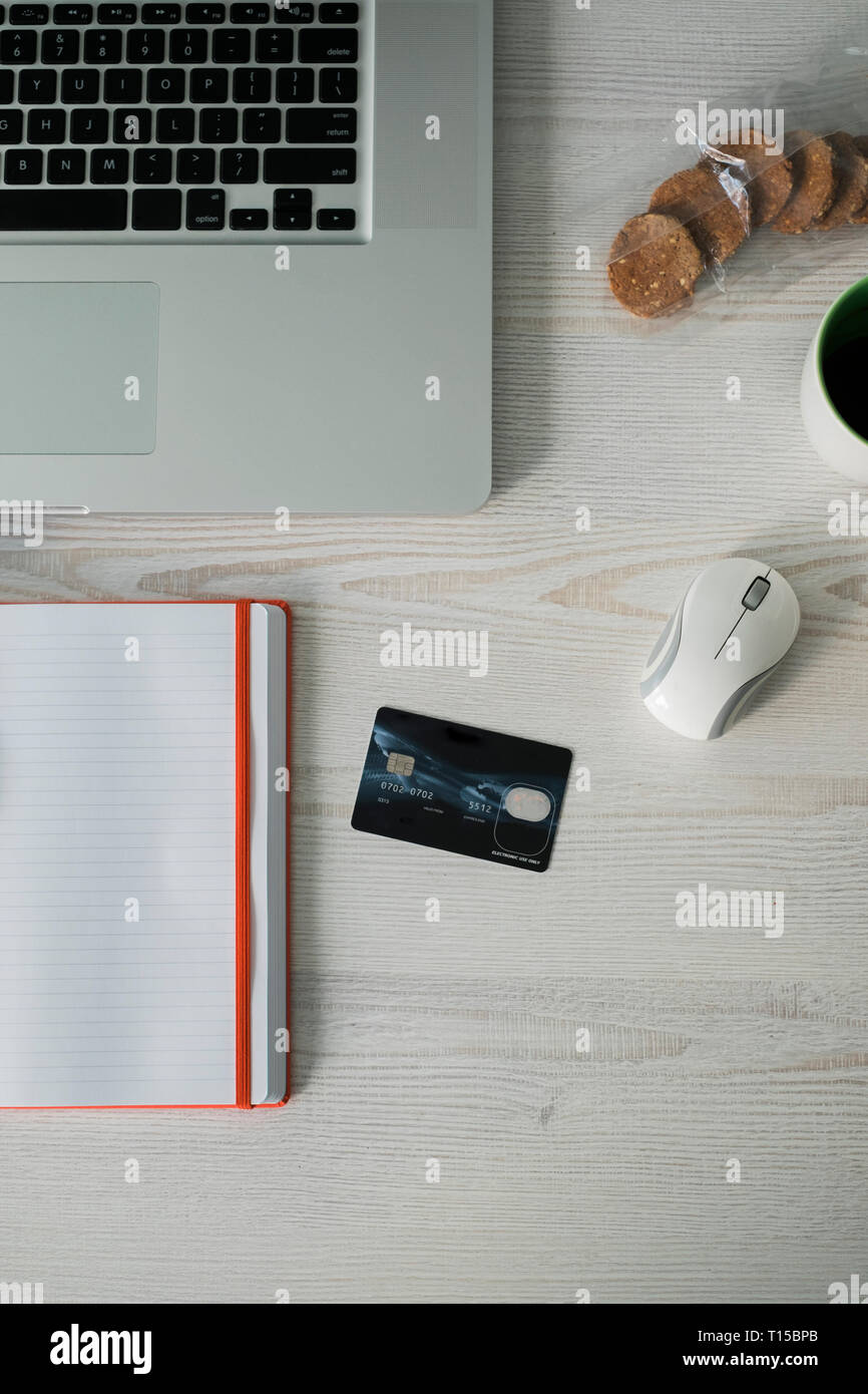 Office desk with laptop, opened notebook, credit card, computer mouse ...