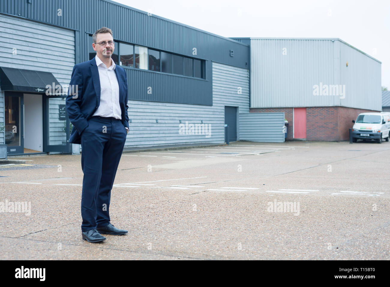 A businessman standing while wearing a suit and looking smart in a ...