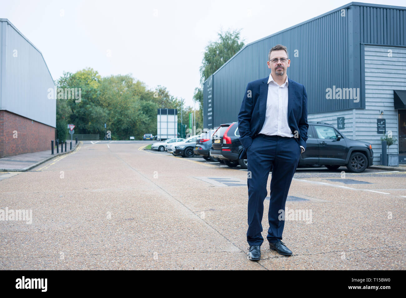 A businessman standing while wearing a suit and looking smart in a ...